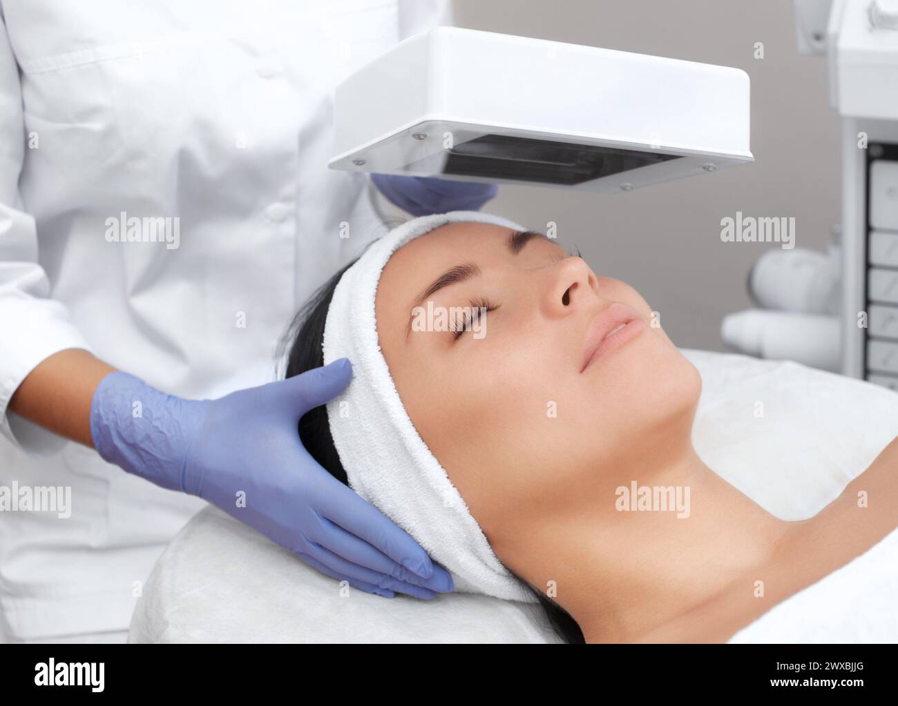 The cosmetologist uses the Wood Lamp for detailed diagnosis of the skin ...