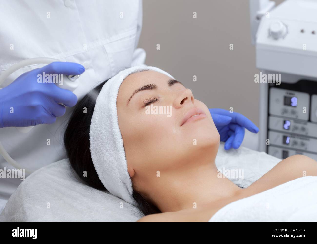The procedure of steaming the skin of the face of a young woman before ...