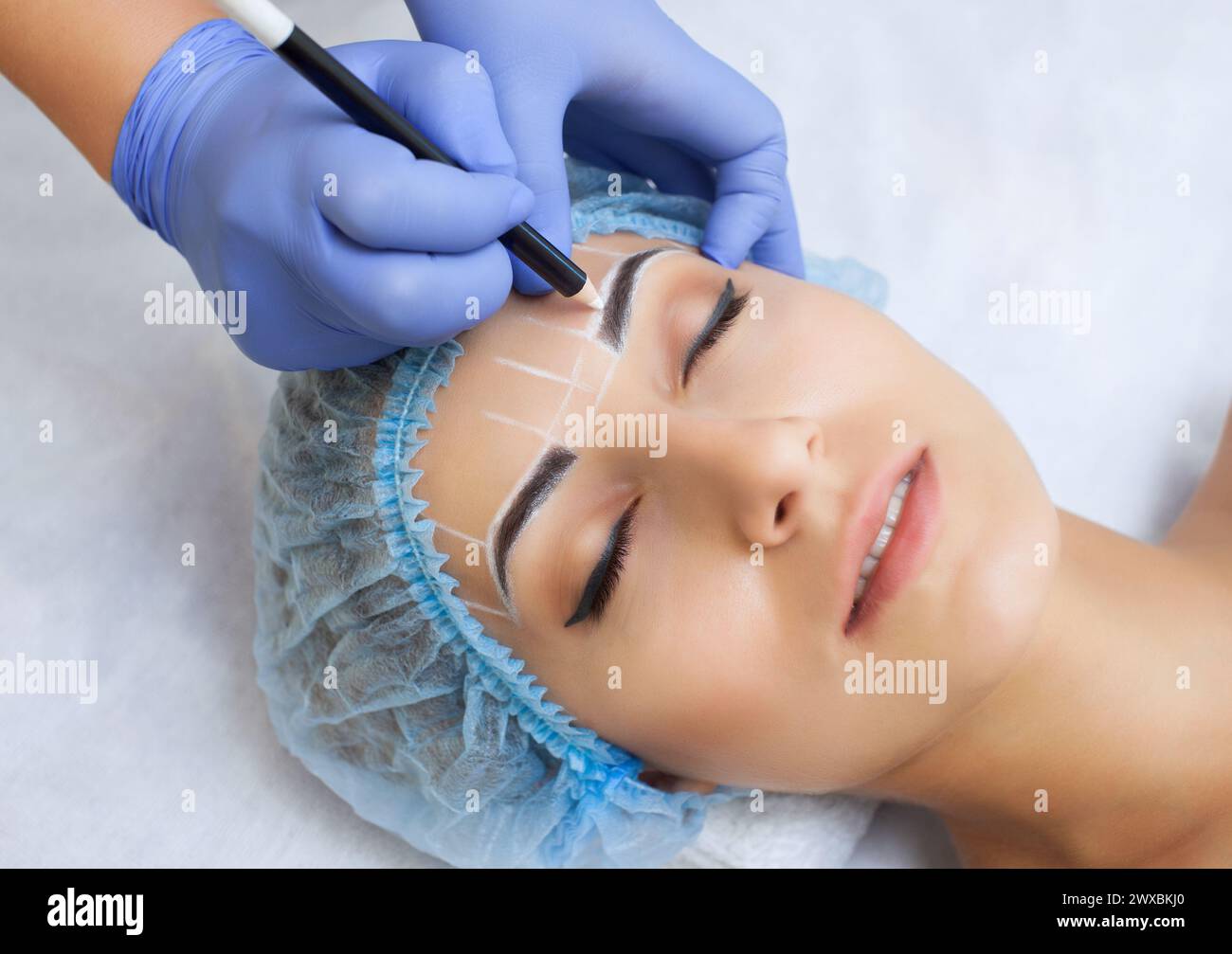 Permanent make-up for eyebrows of beautiful woman with thick brows in ...