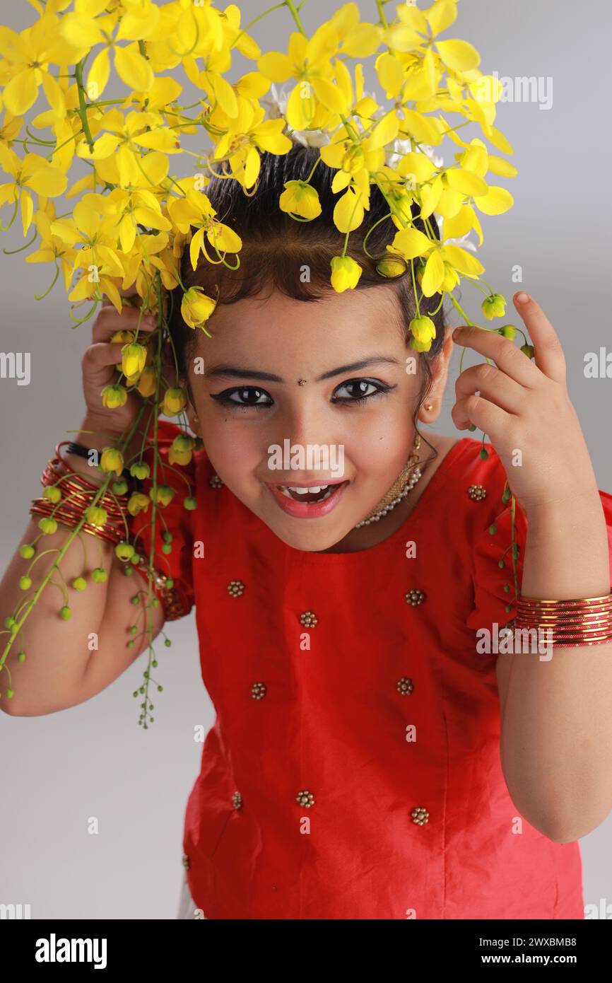 A cute small girl child wearing Kerala dress-golden colour long skirt and red blouse with golden ...