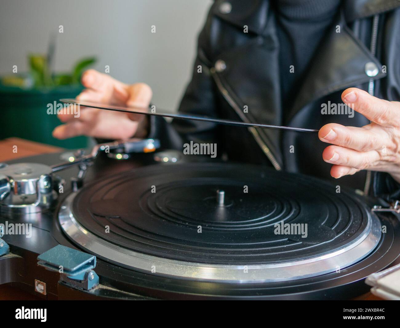 An unrecognizible lady holding a vinyl record ready to play it on her ...
