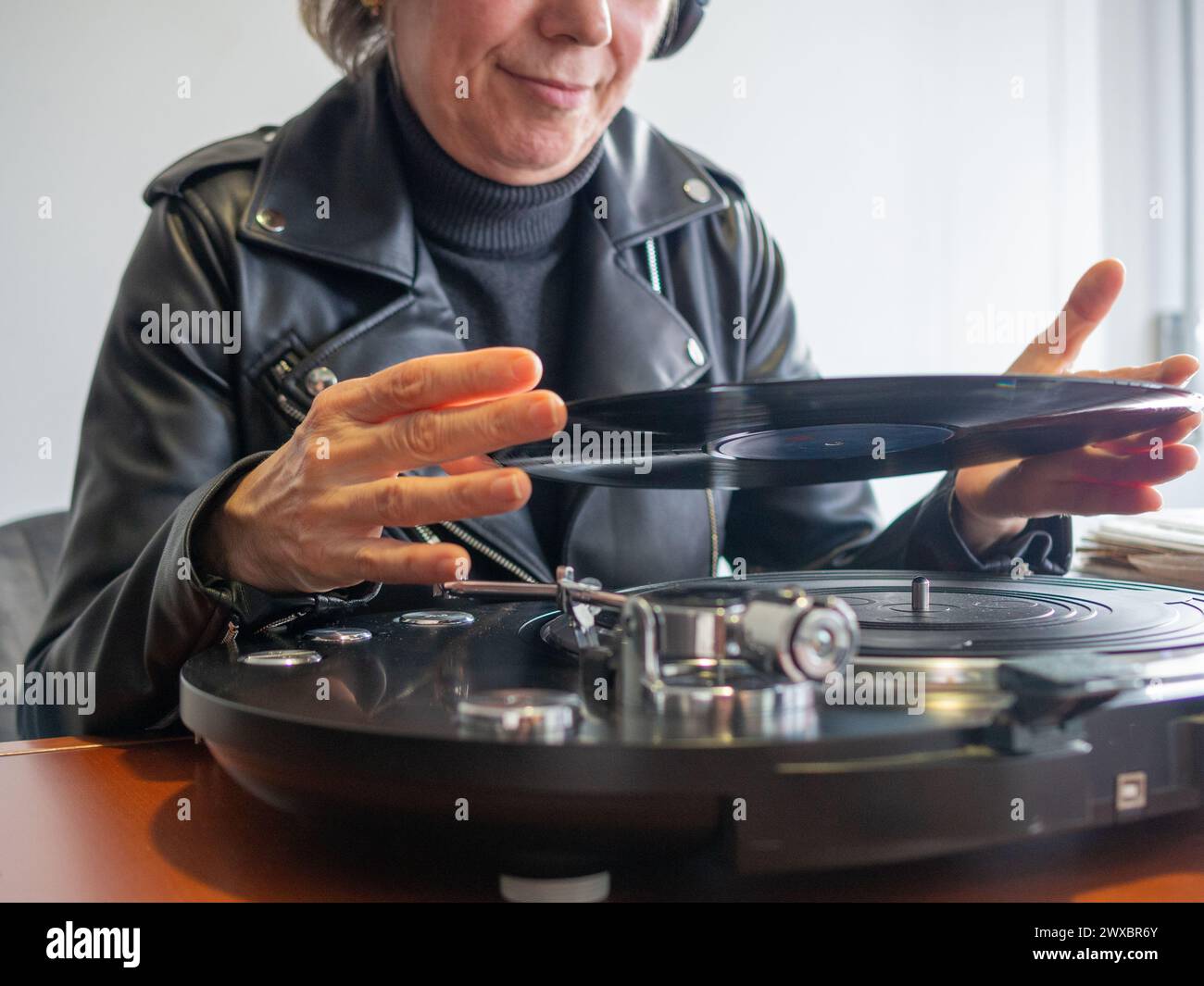 An unrecognizible lady holding a vinyl record ready to play it on her ...