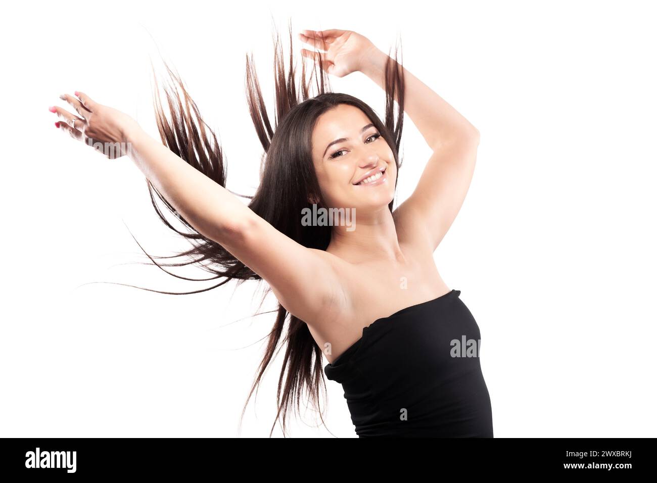 Young woman with long dark hair. Standing confidently in against white ...