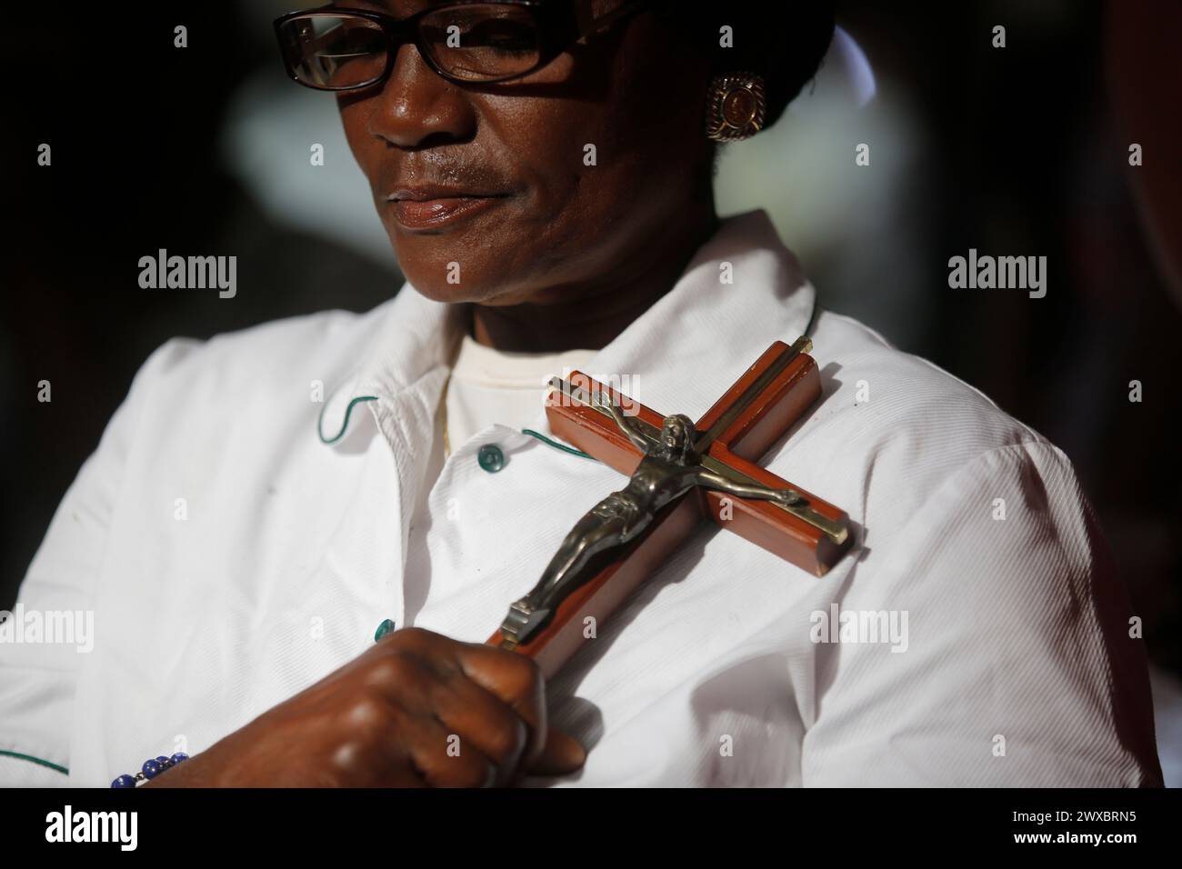 A woman holds a crucifix during a Good Friday service as part of Holy ...