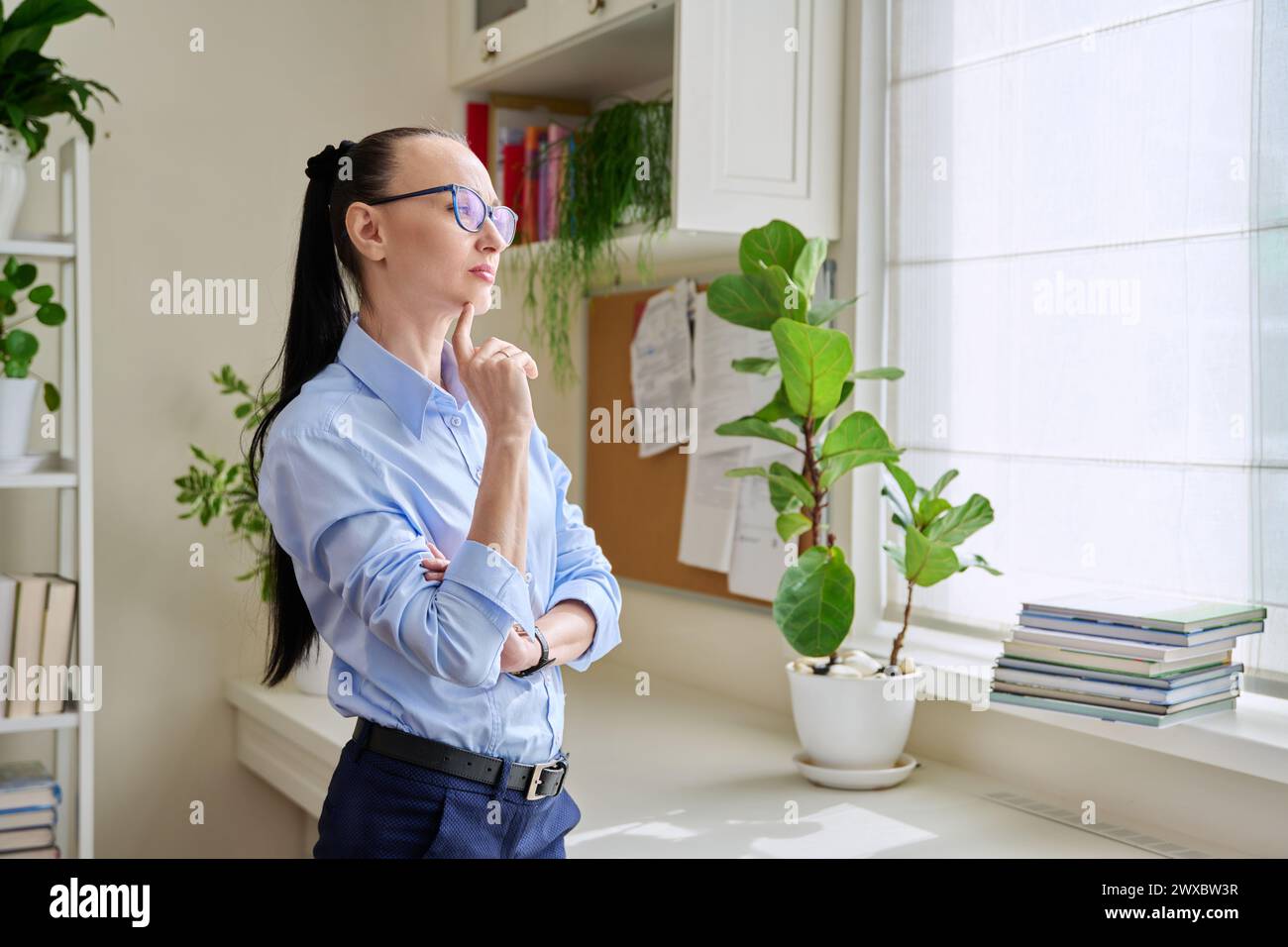 Serious thoughtful woman in her 30s looking out the window Stock Photo ...