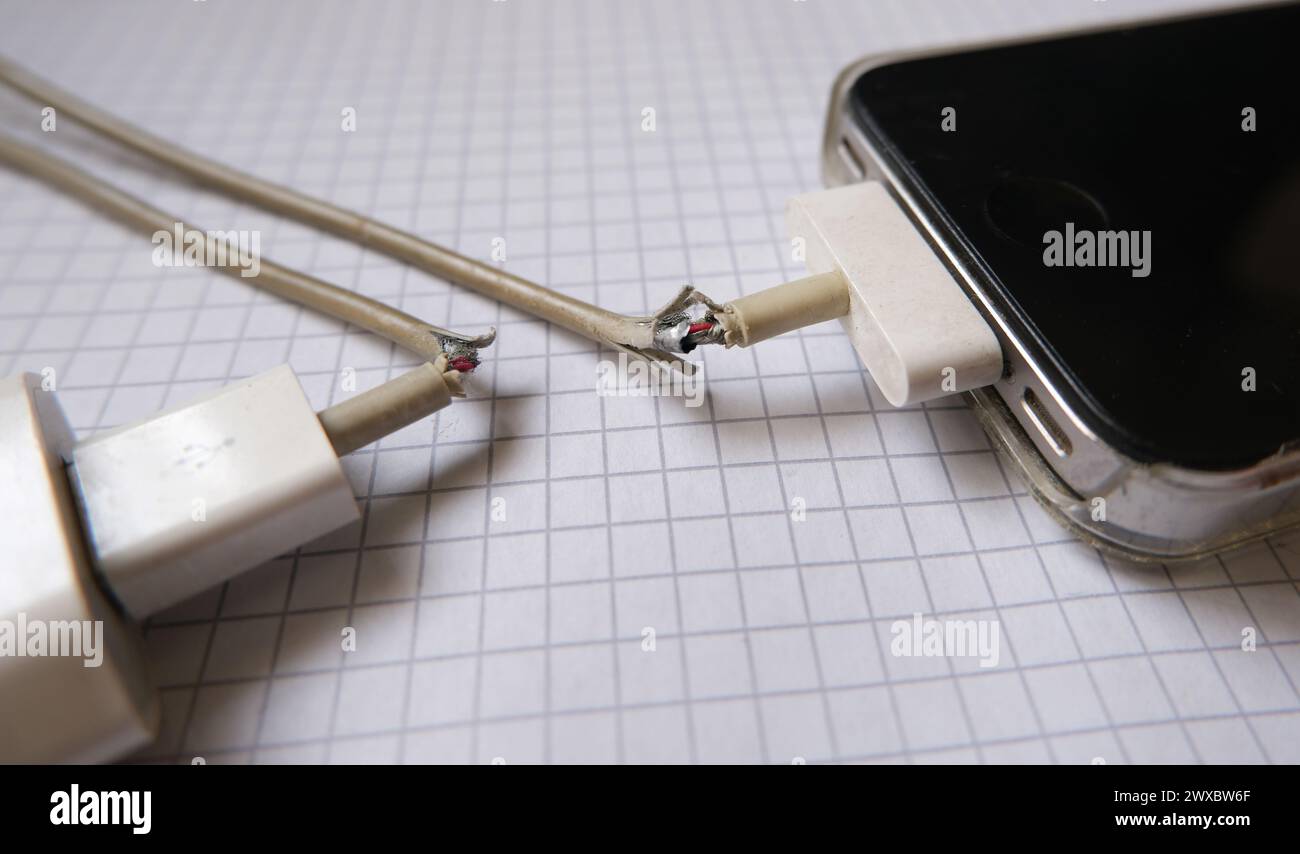 Fraying mobile charger cable. Extremely worn electrical wires. Broken and blown insulation of ...