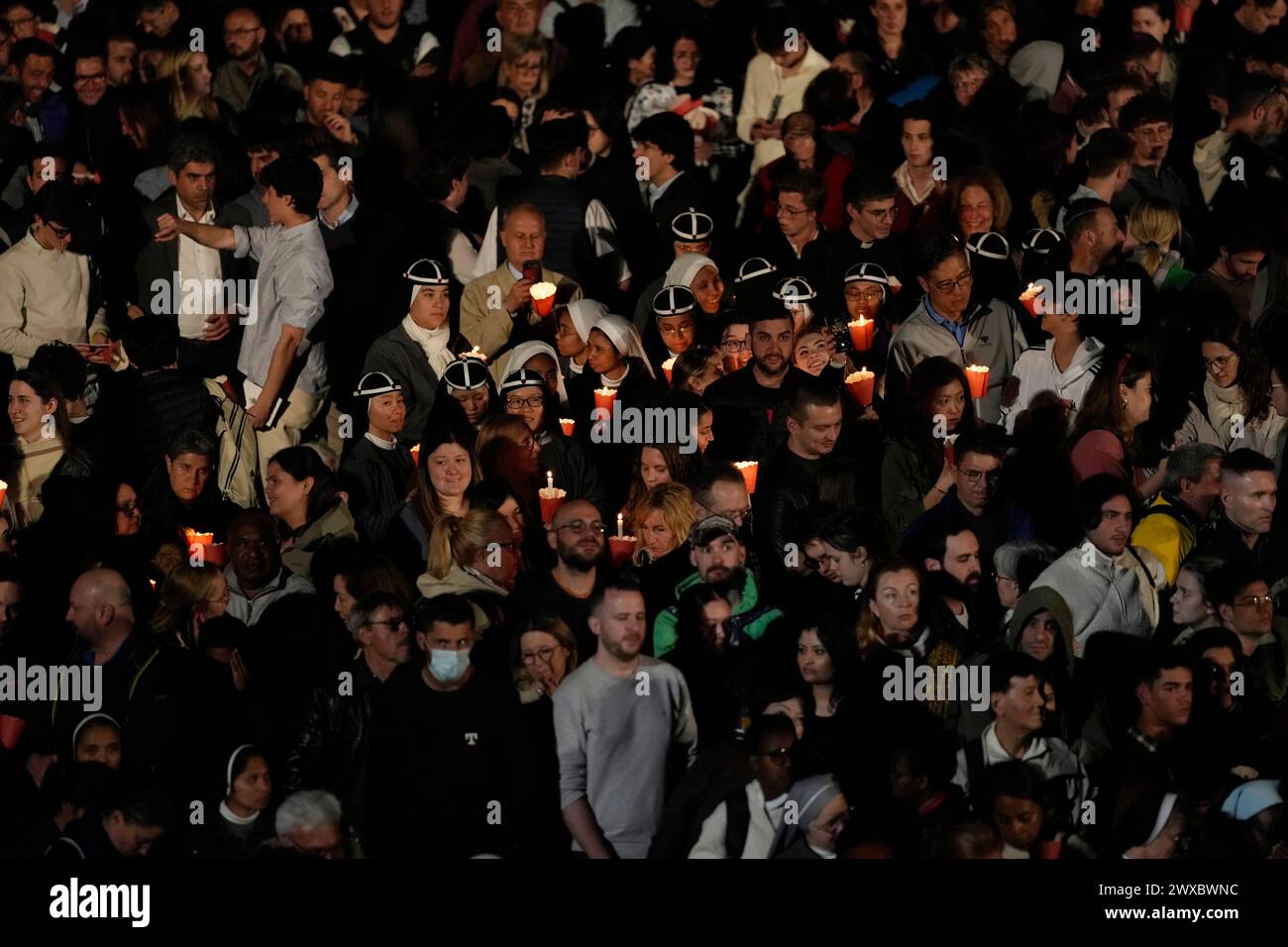 People stand in front of the Colosseum during a Via Crucis (Way of the ...
