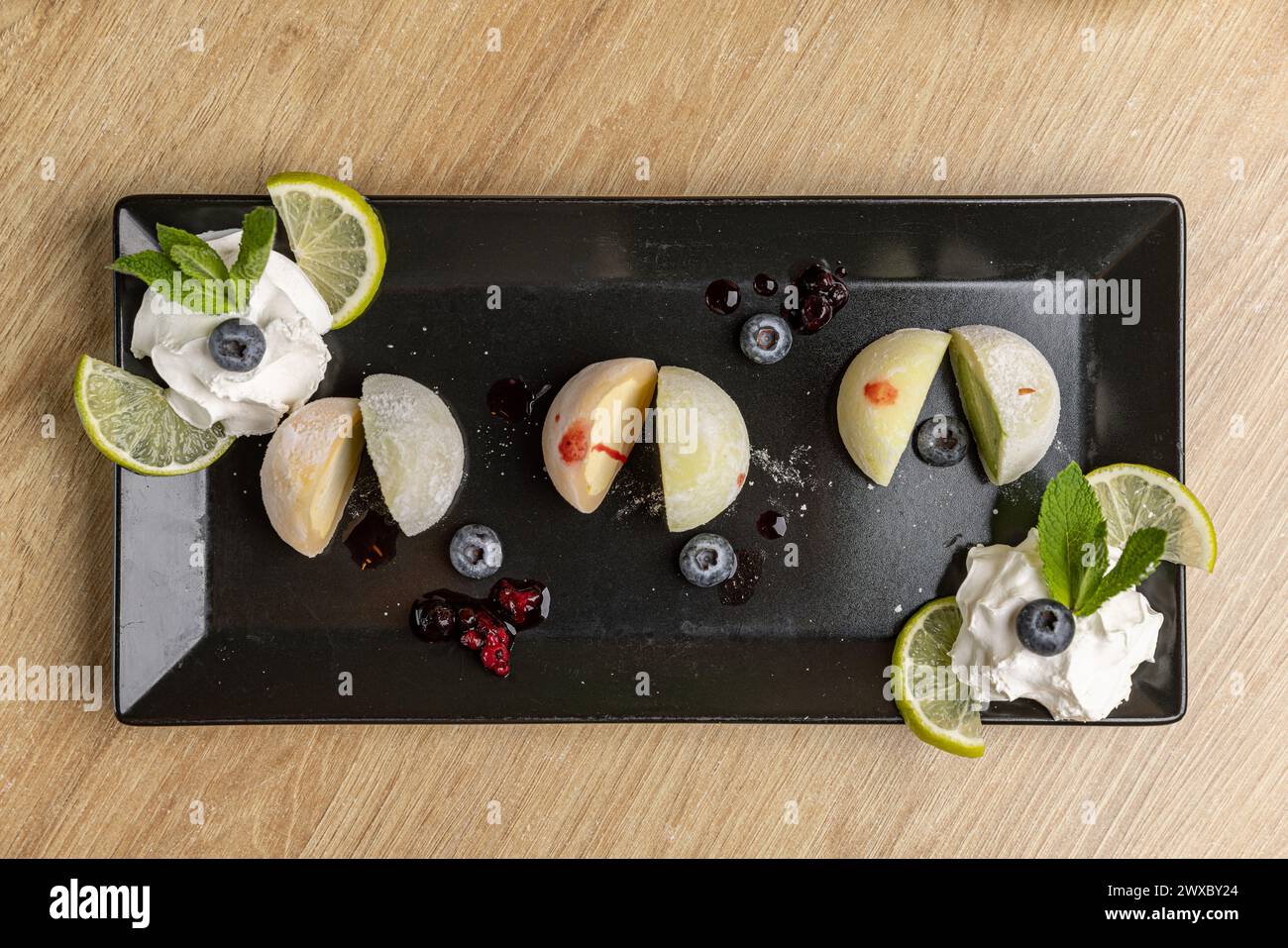 Elegant mochi ice cream dessert platter with fresh fruit slices and ...