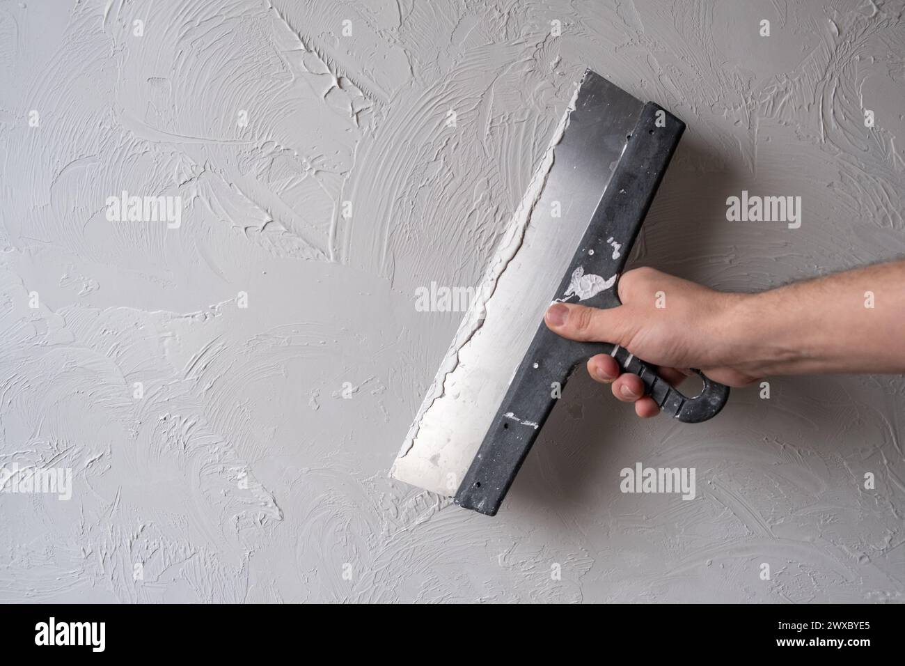 Applying decorative putty. White abstract texture of surface covered ...