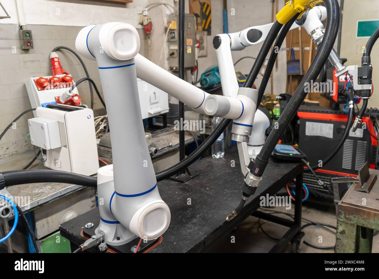 A modern welding robot in an old crowded welding workshop Stock Photo ...