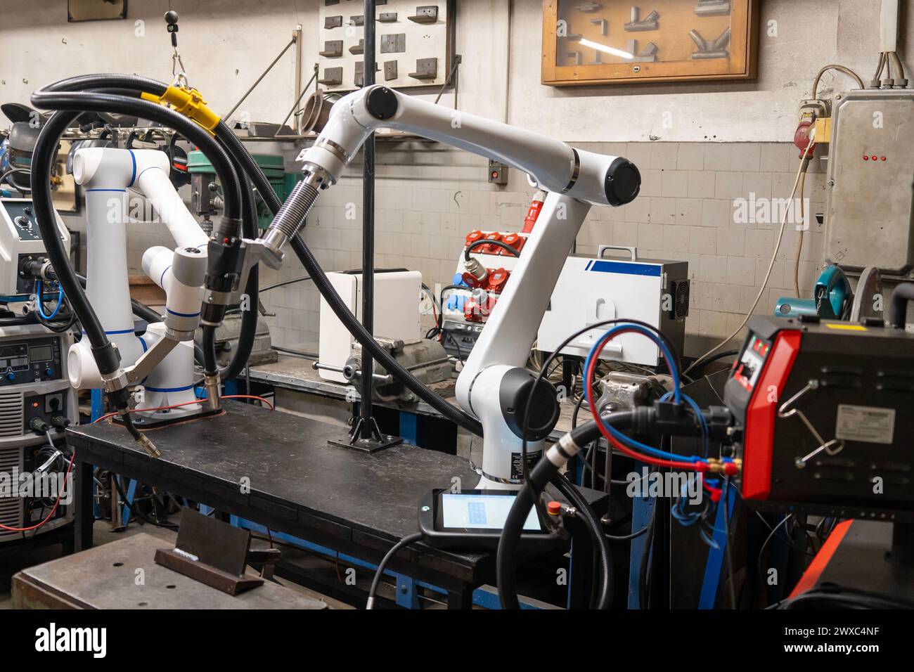 A modern welding robot in an old crowded welding workshop Stock Photo ...