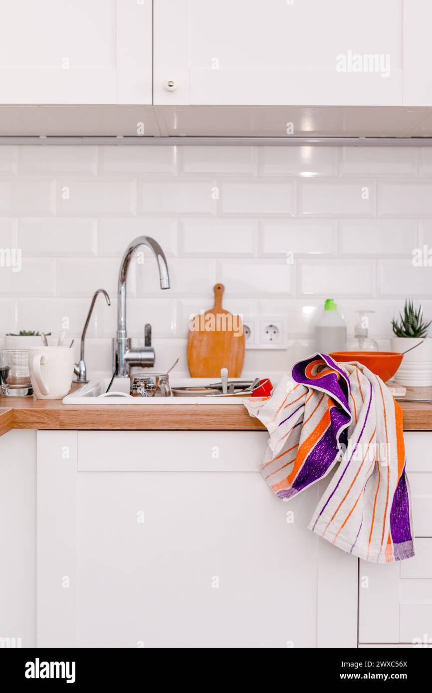 Clutter, dirty dishes by the sink in the white kitchen Stock Photo - Alamy