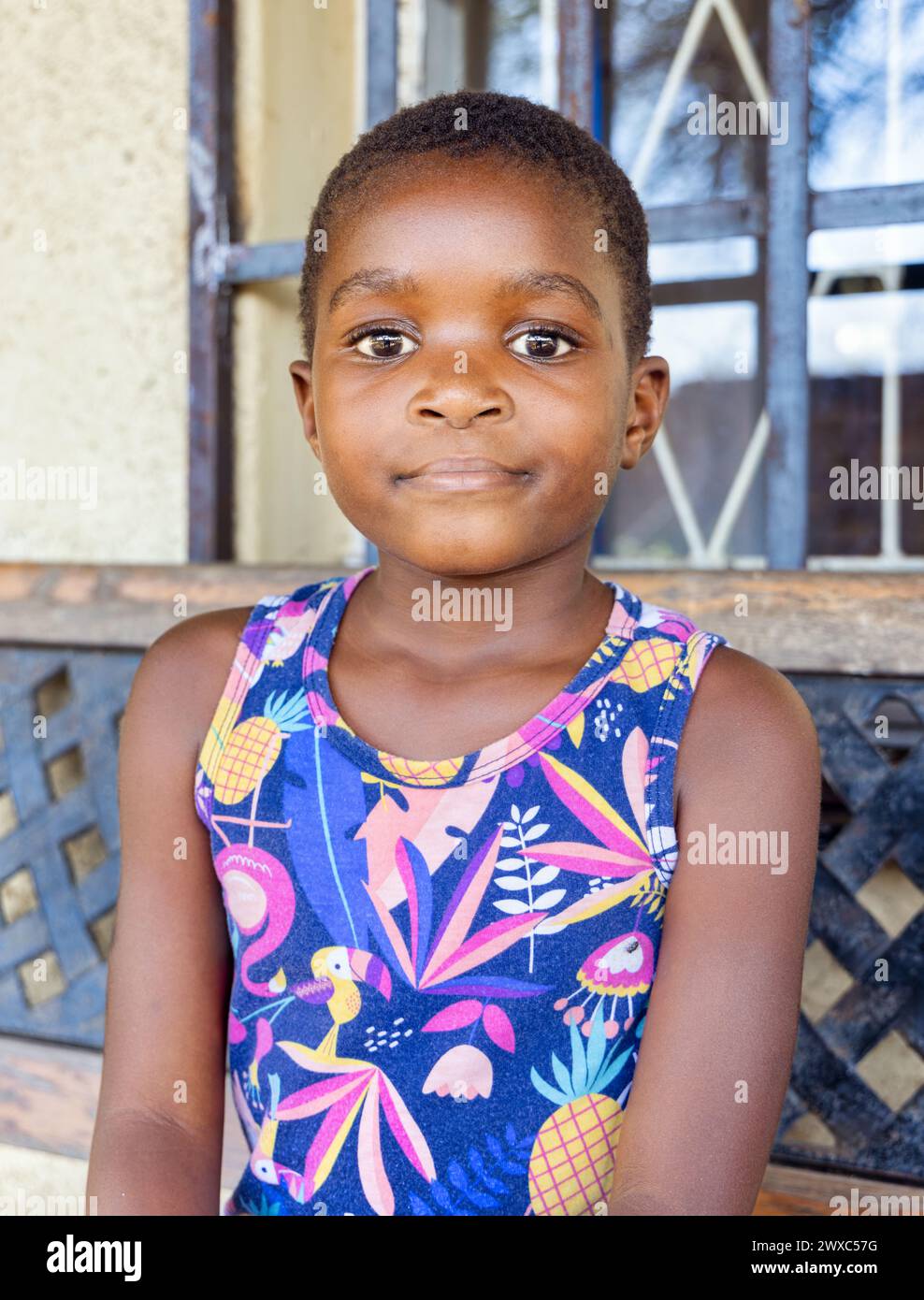 single african child girl in the ghetto, standing on a bench at home ...