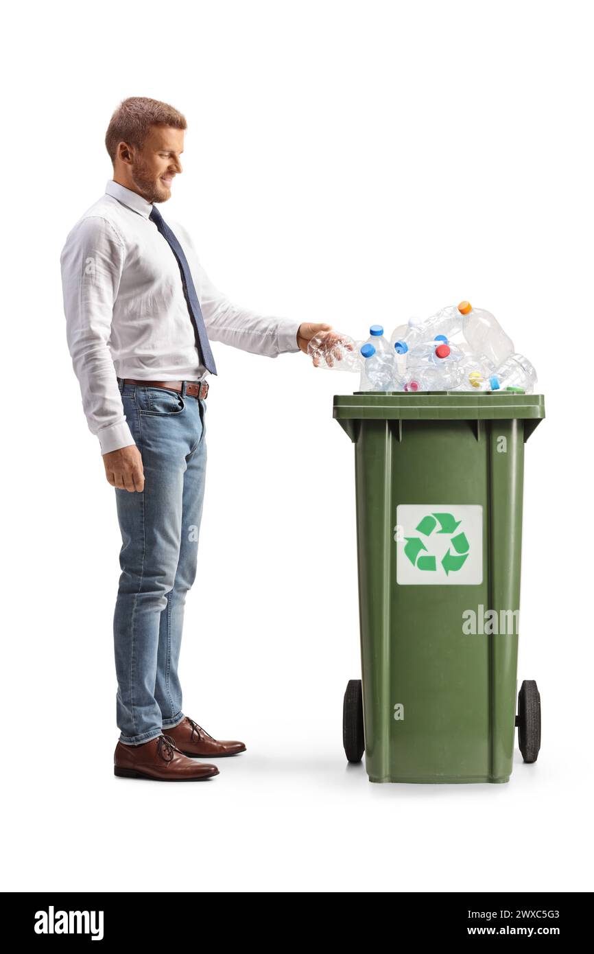 Full length profile shot of a man throwing a plastic bottle in a trash ...