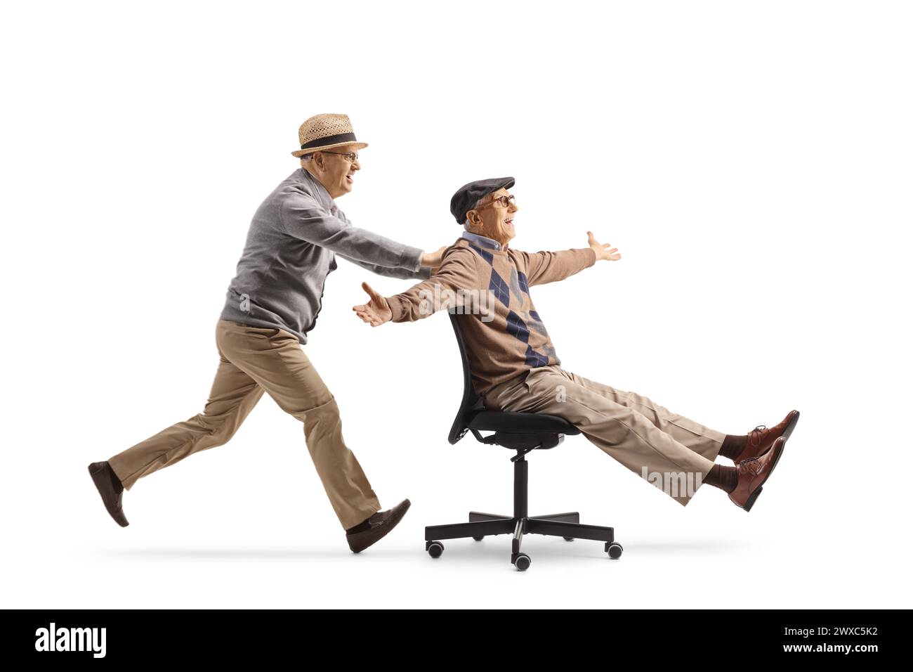 Elderly man running and pushing a friend in an office chair isolated on ...