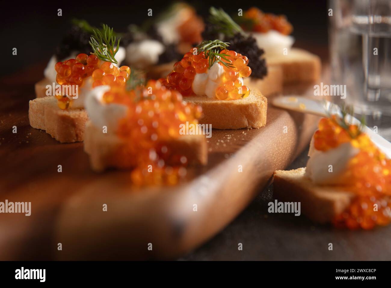 three varieties of caviar and two shots of vodka with a shallow depth ...