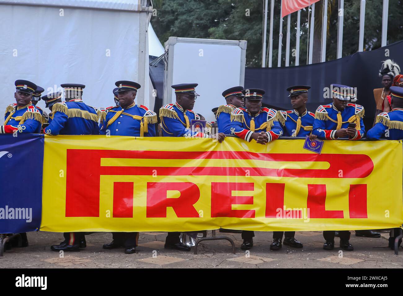 Kenya police band take a moment to watch rally cars after playing the national anthem during the ...