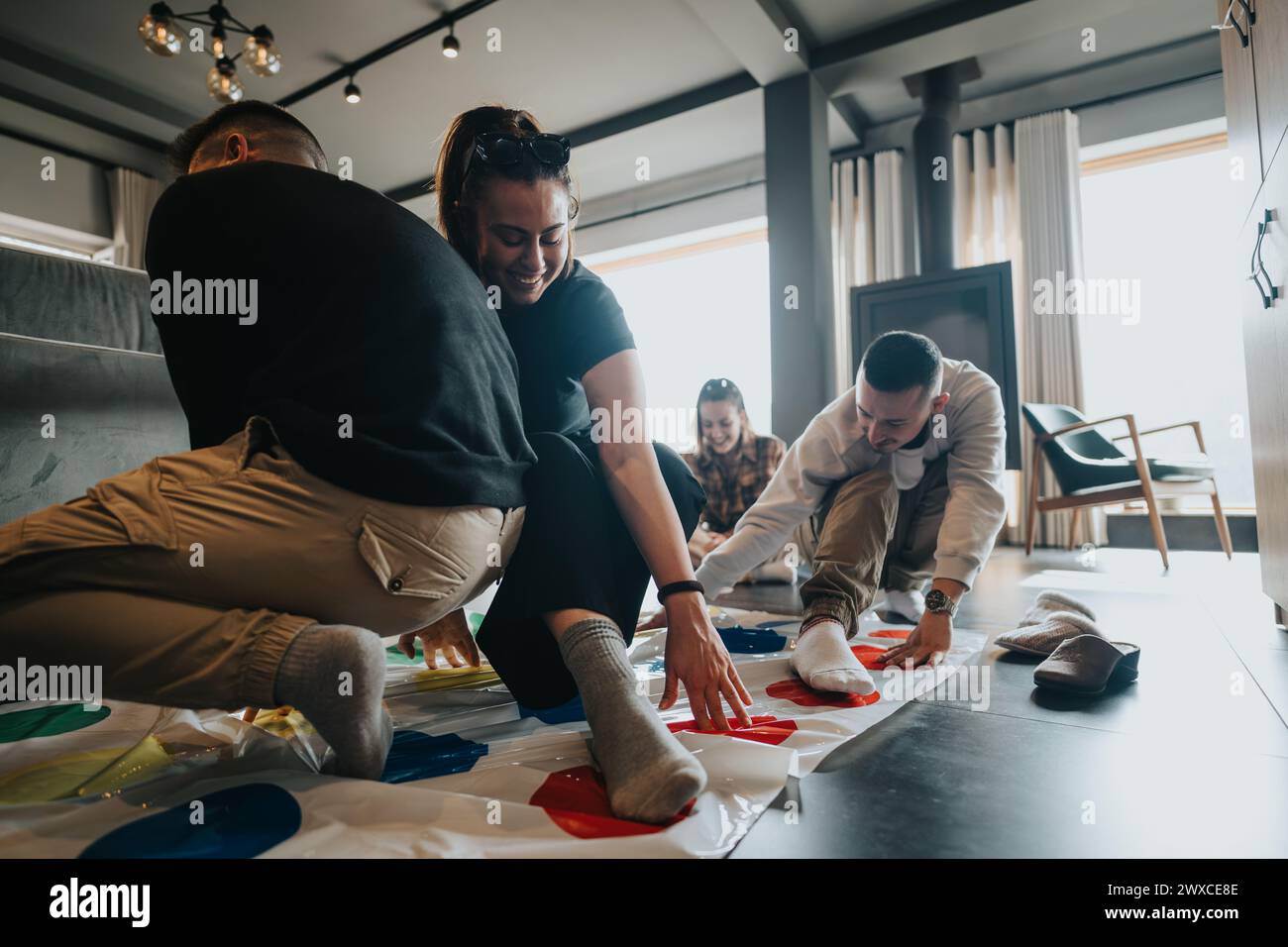 Group of friends playing twister game together in a cozy room Stock ...