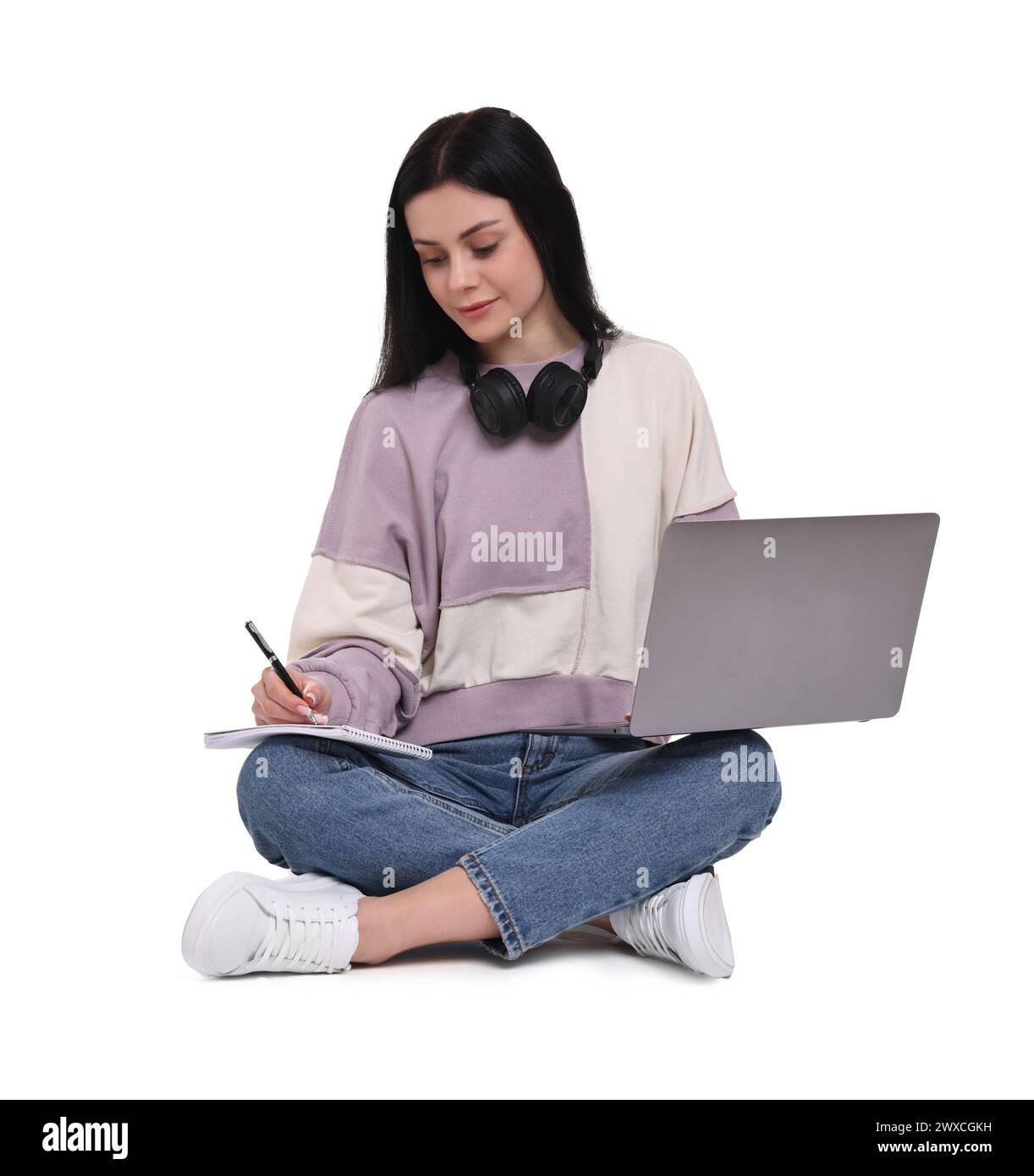 Student with laptop writing in notebook on white background Stock Photo ...