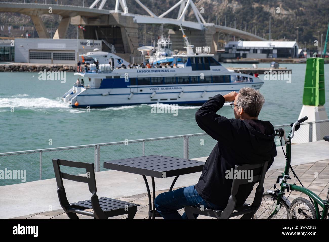 A person is seen enjoying the landscape of the Port of Barcelona ...