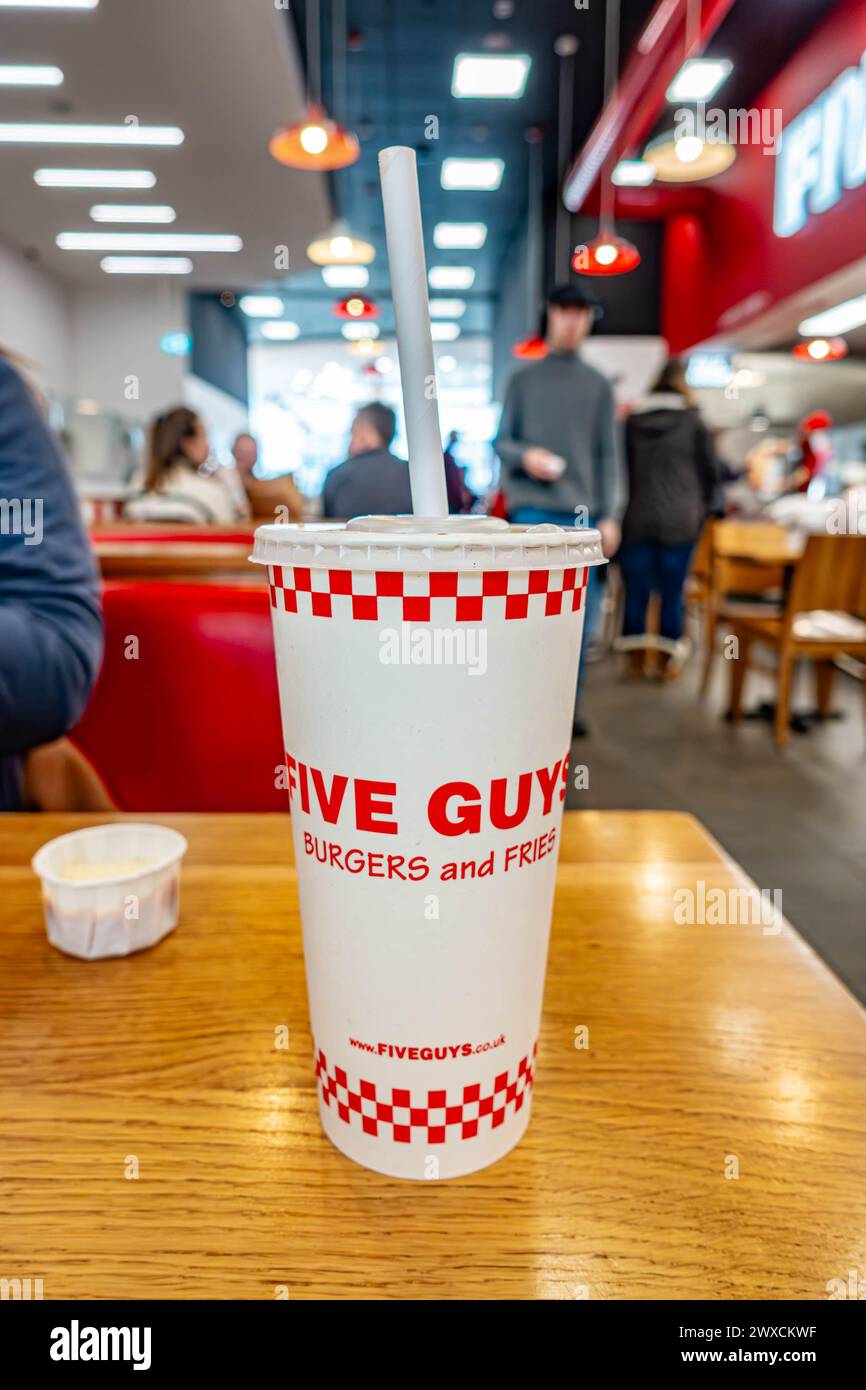 A fizzy drink on a table in a disposable paper cup on a table in a Five Guys restaurant Stock ...