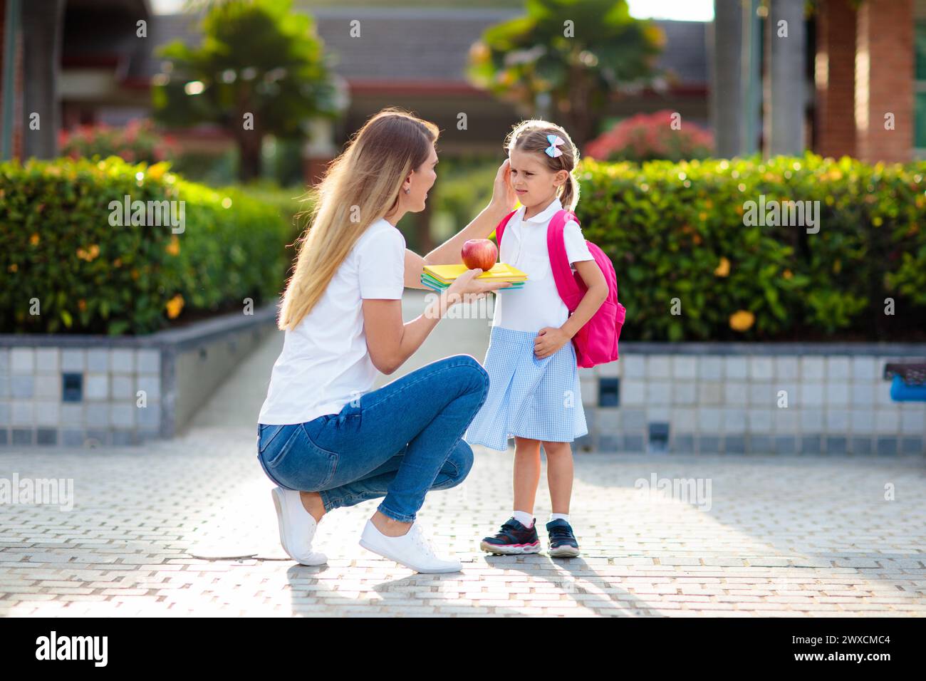 Mother and kids after school. Young mom picking up children after ...