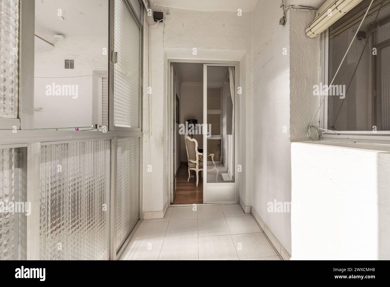 A small white painted terrace closed with translucent glazing with ...