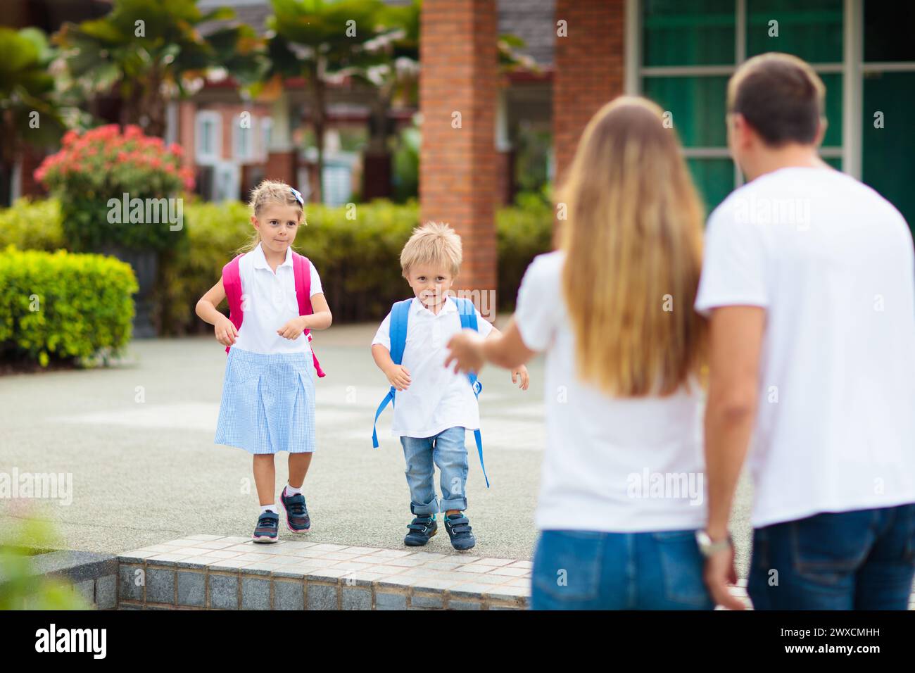 Mother and kids after school. Young mom picking up children after ...