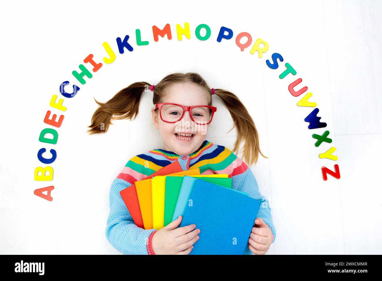 Happy preschool child learning to read and write playing with colorful ...