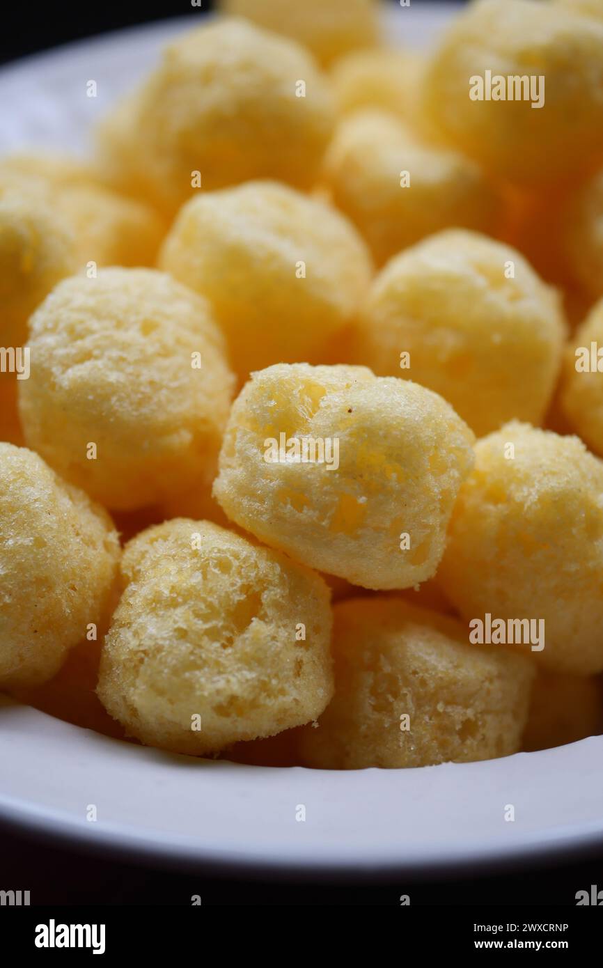 puffed corn rings chips on black background Stock Photo - Alamy