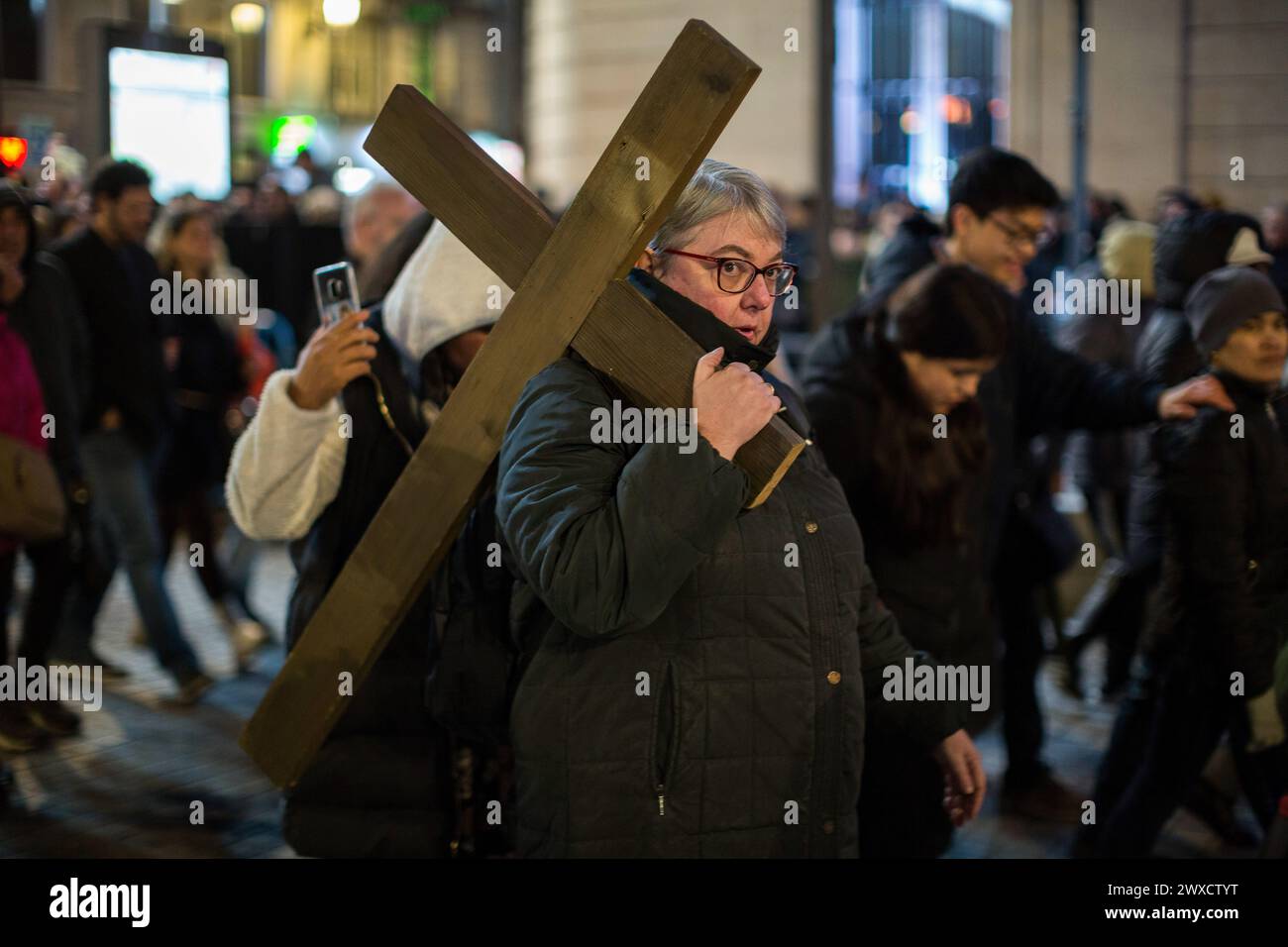 Madrid, Spain. 29th Mar, 2024. A penitent carries a cross on her ...