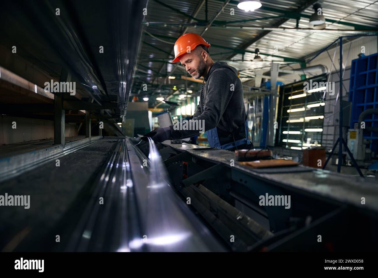 Middle-aged male is gluing spacer frames at a window factory Stock ...