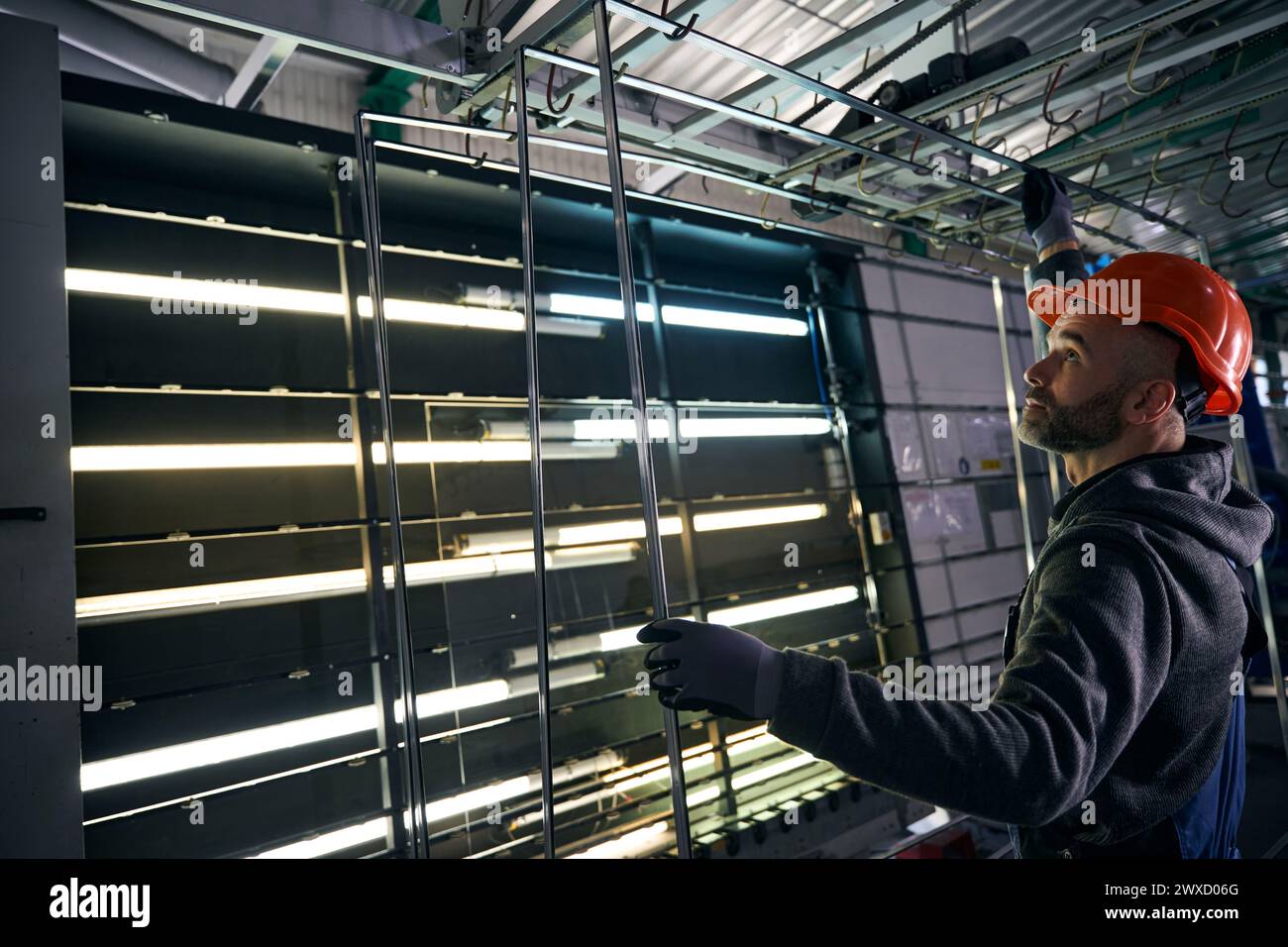 Man with beard glues spacer frames at window production facility Stock ...