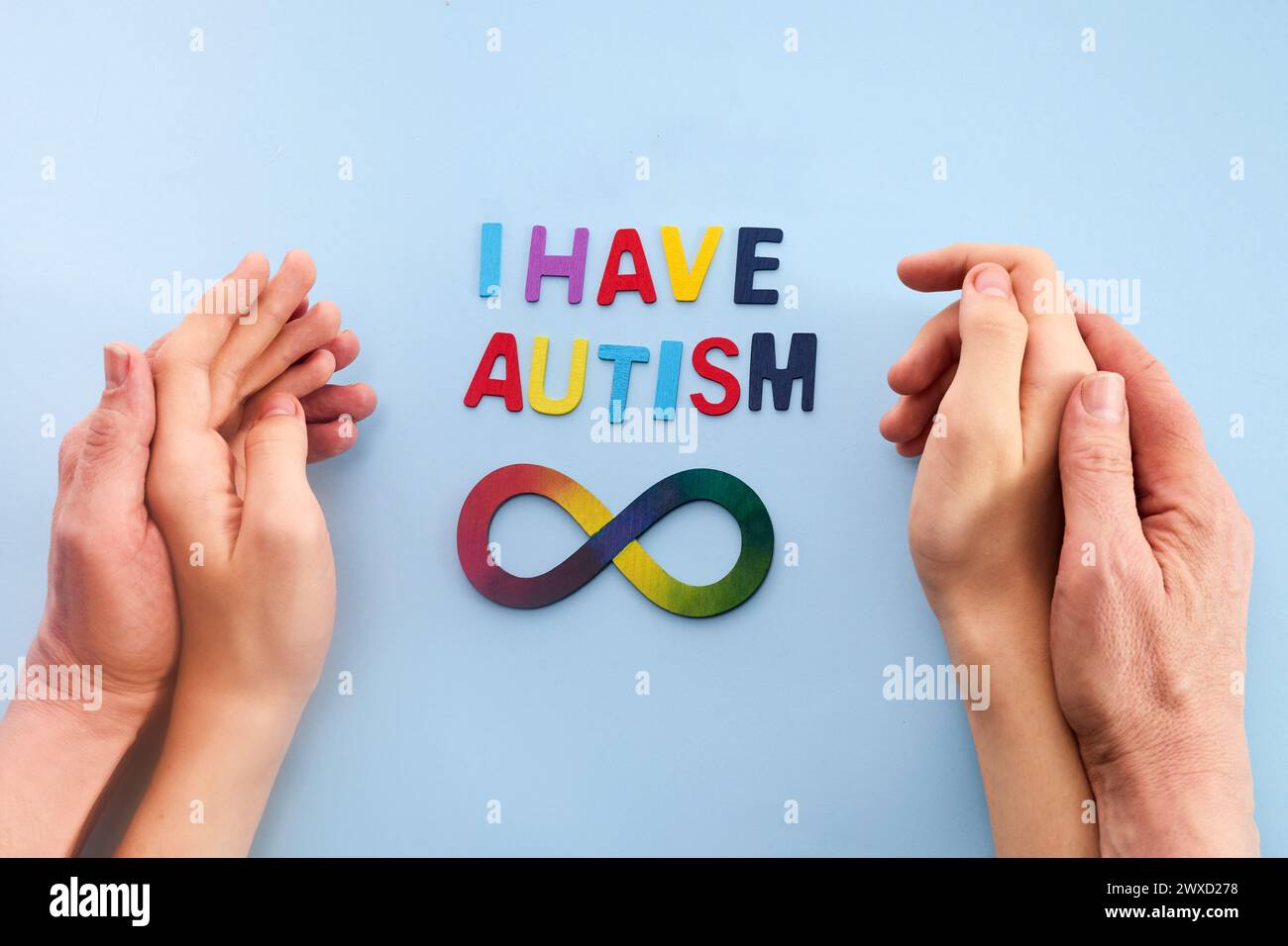 Autistic boy and father hands with rainbow eight infinity symbol ...