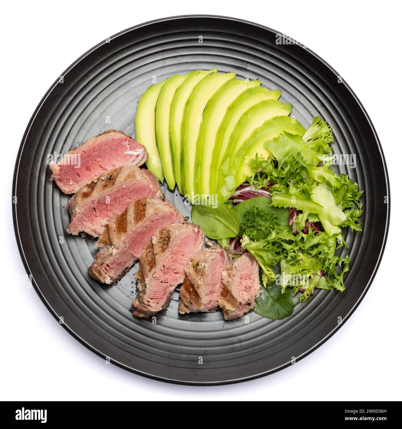 grilled cooked piece of tuna fillet with sliced avocado and salad on ...
