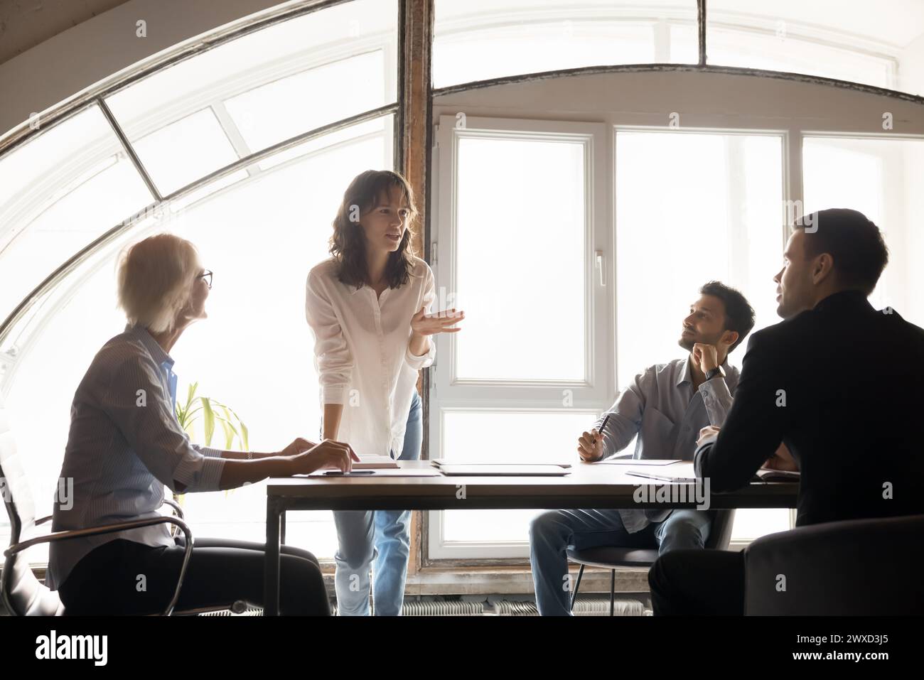 Serious young project manager woman explaining marketing strategy to ...