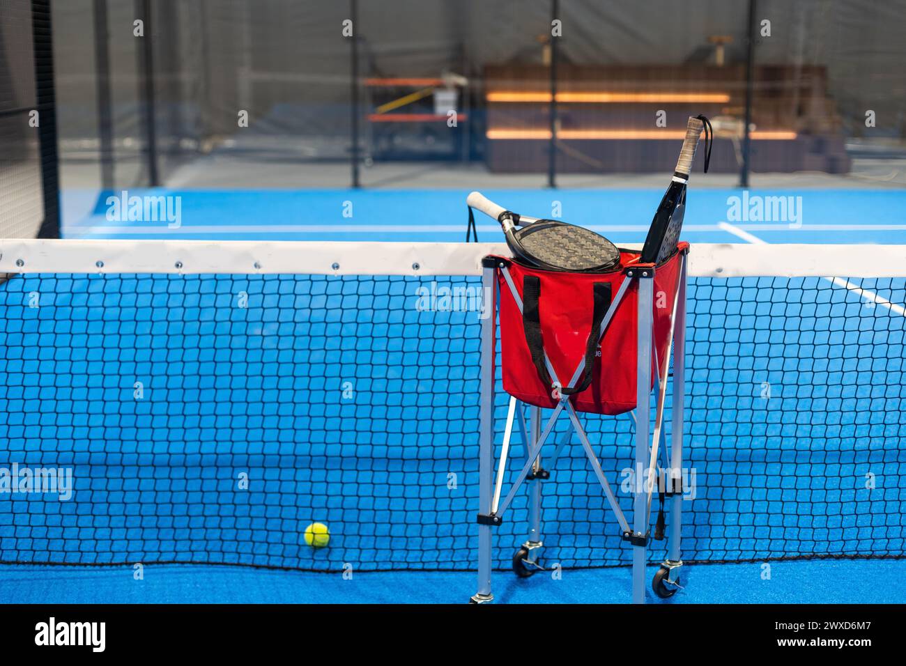 Paddle tennis: Paddel racket and ball in front of an outdoor court ...