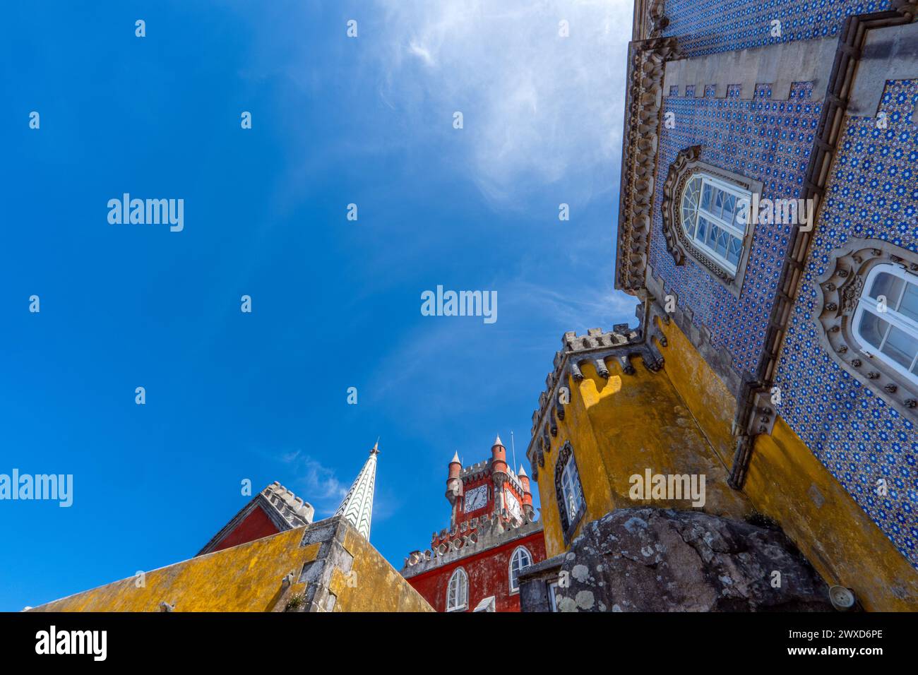 Exterior view of the Pena Palace with walls and yellow and red mosaics ...