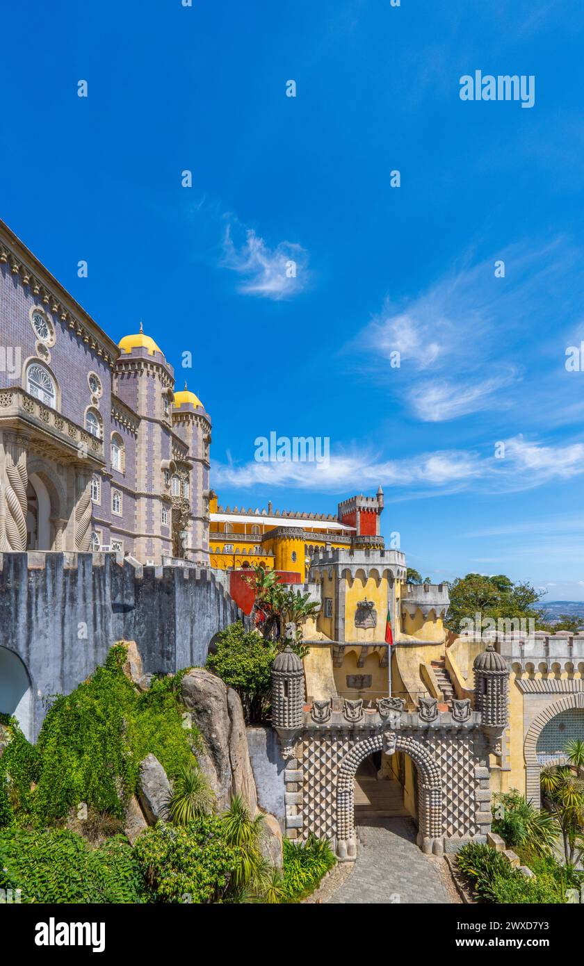 Exterior and wide view of the Pena Palace of yellow, red and mosaic ...