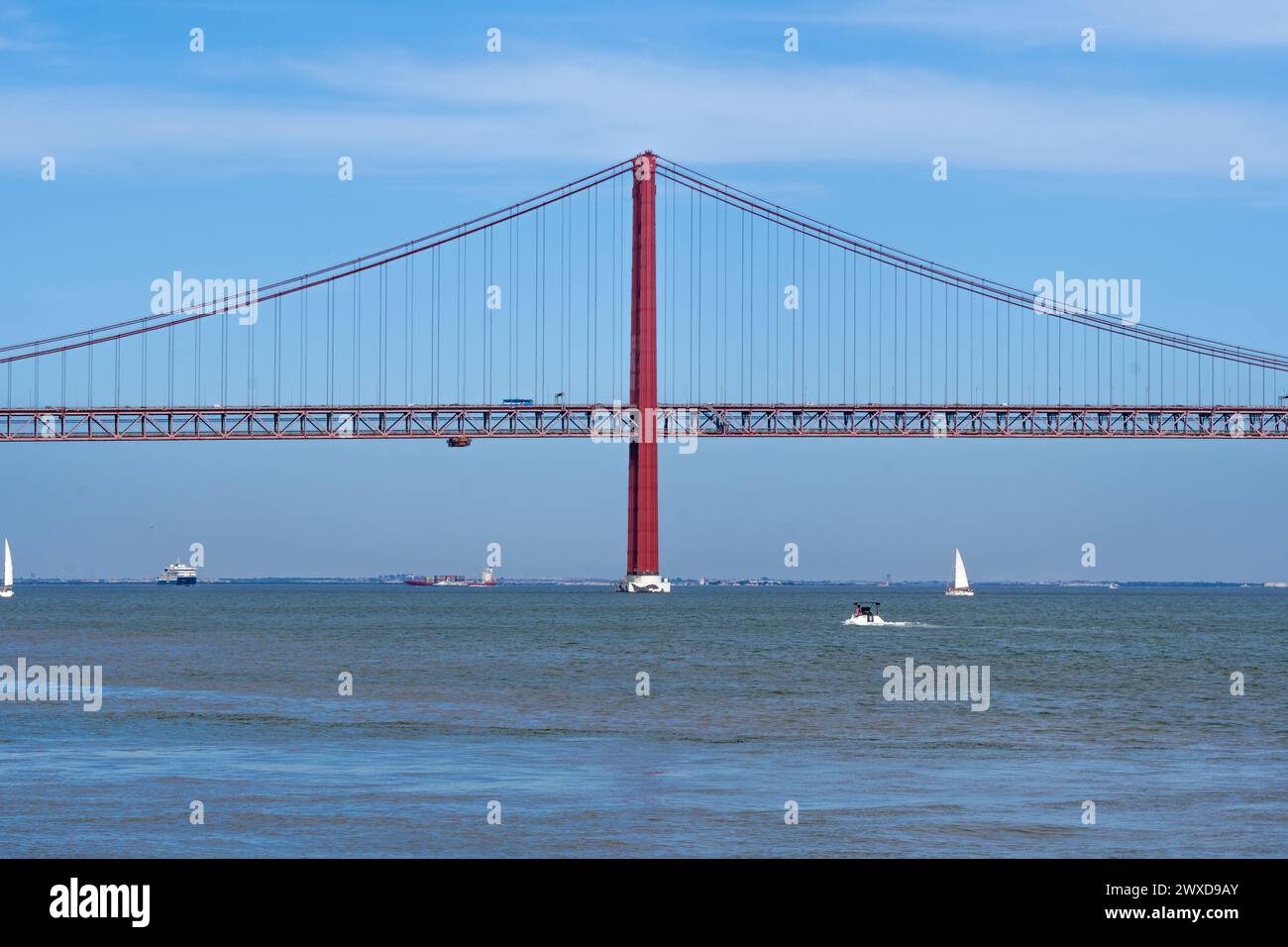 Container ship, motorboats and sailboats navigating the Tagus River ...