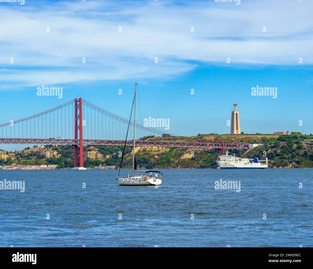 Sailboat and white ferry sailing along the Tajo River with the 25 de ...