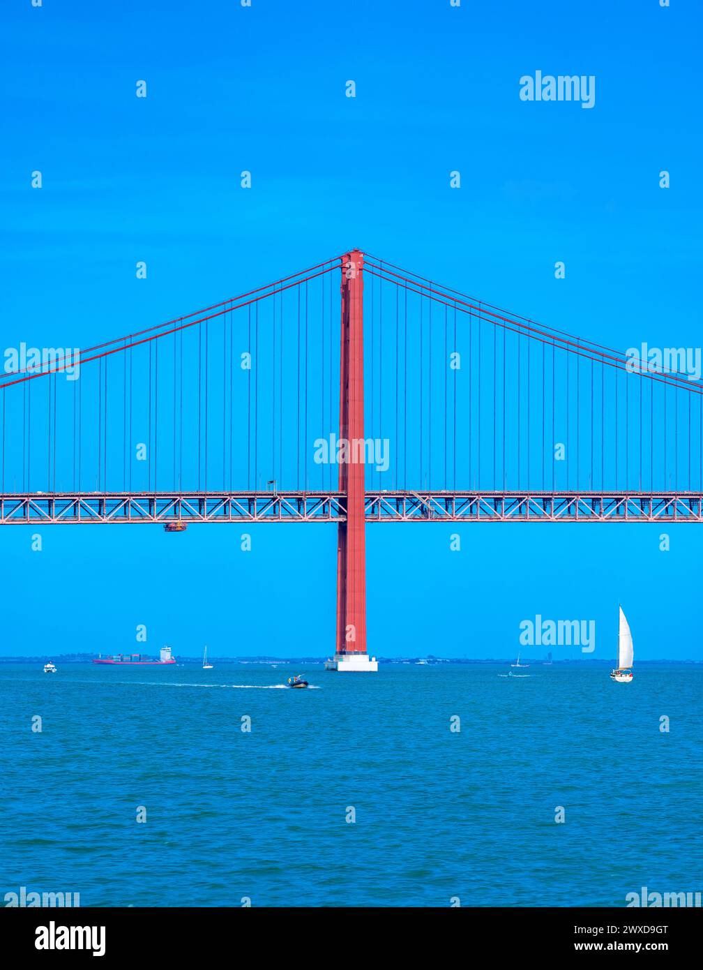 Container ship, motorboats and sailboats navigating the Tagus River ...