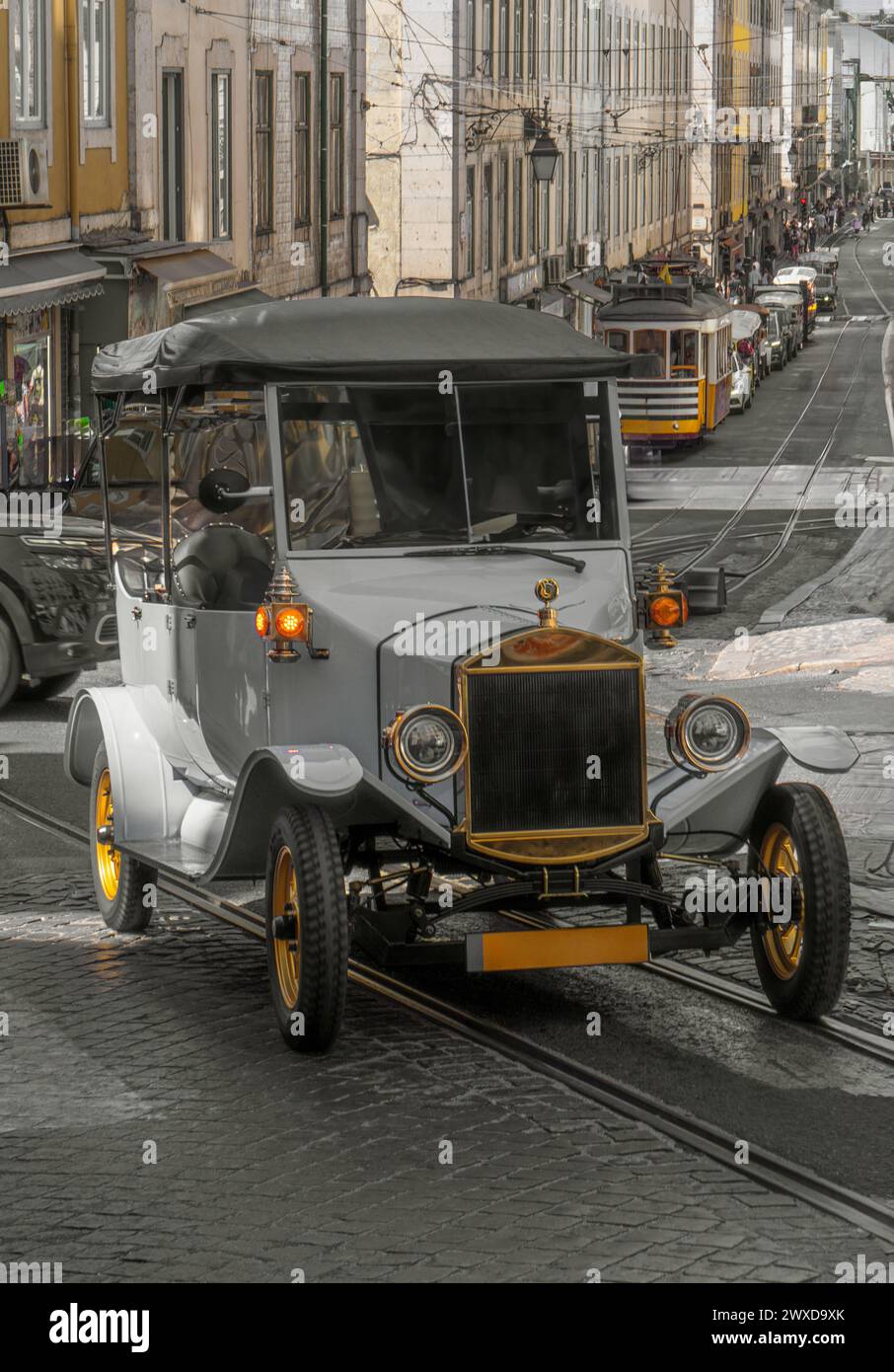 Replica of an old gray electric tourist car going up the slope of a ...