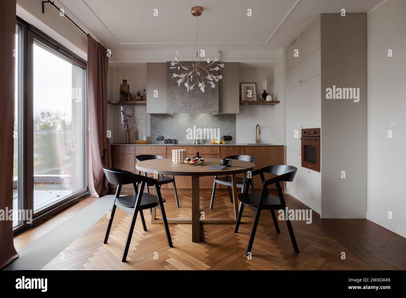 Dining area with table, chairs, and kitchen in the background Stock ...