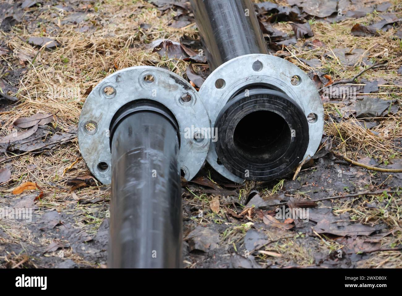 Clear bolts and screws. The pipes are located on the ground in nature ...