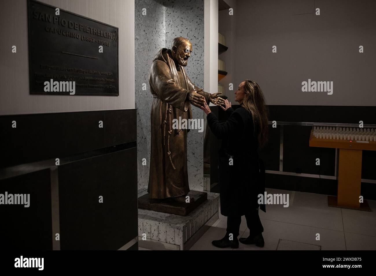 Madrid, Spain. 29th Mar, 2024. A woman holds the hands of Saint Pio of ...