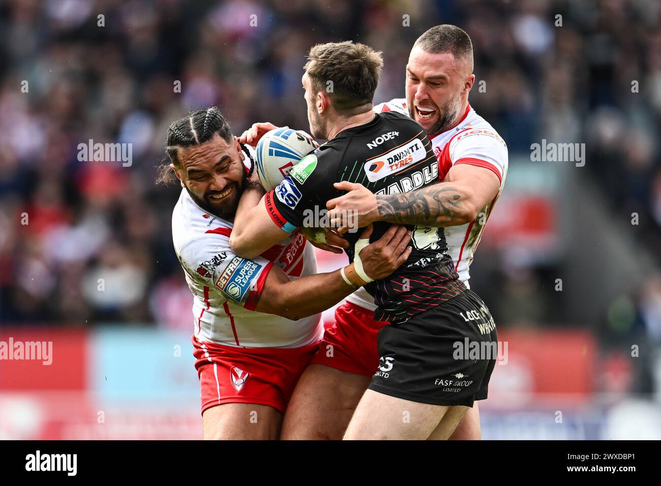 Jake Wardle of Wigan Warriors is tackled by Konrad Hurrell of St ...
