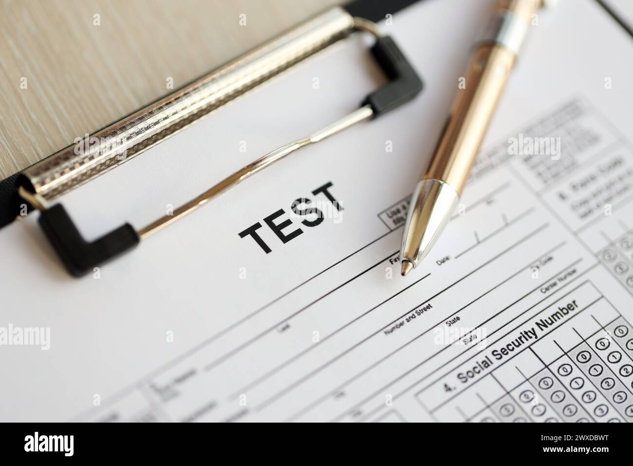 Blank educational test for students lies on table in classroom with pen ...