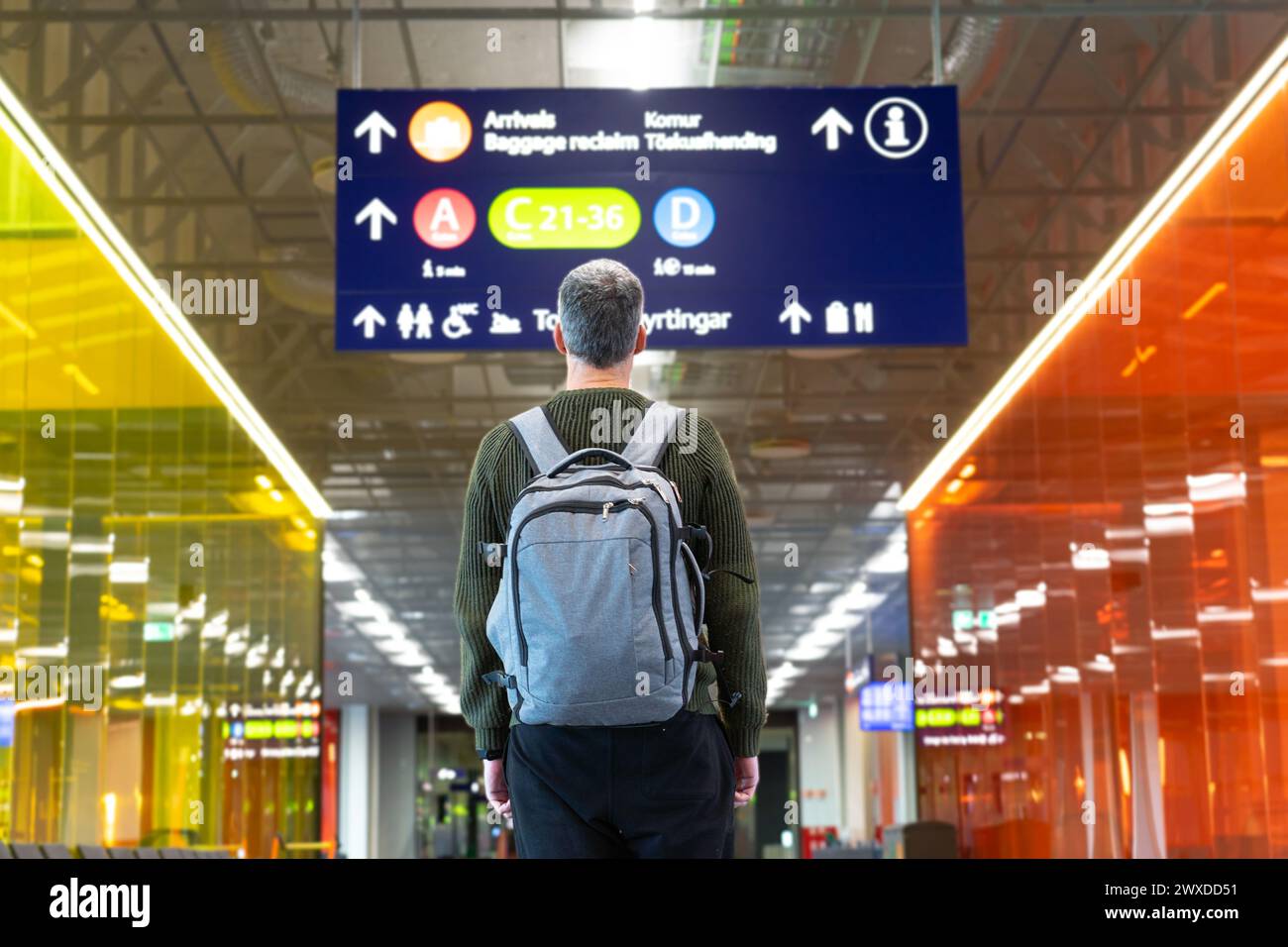 Traveler man looking at a sign in an airport Stock Photo - Alamy