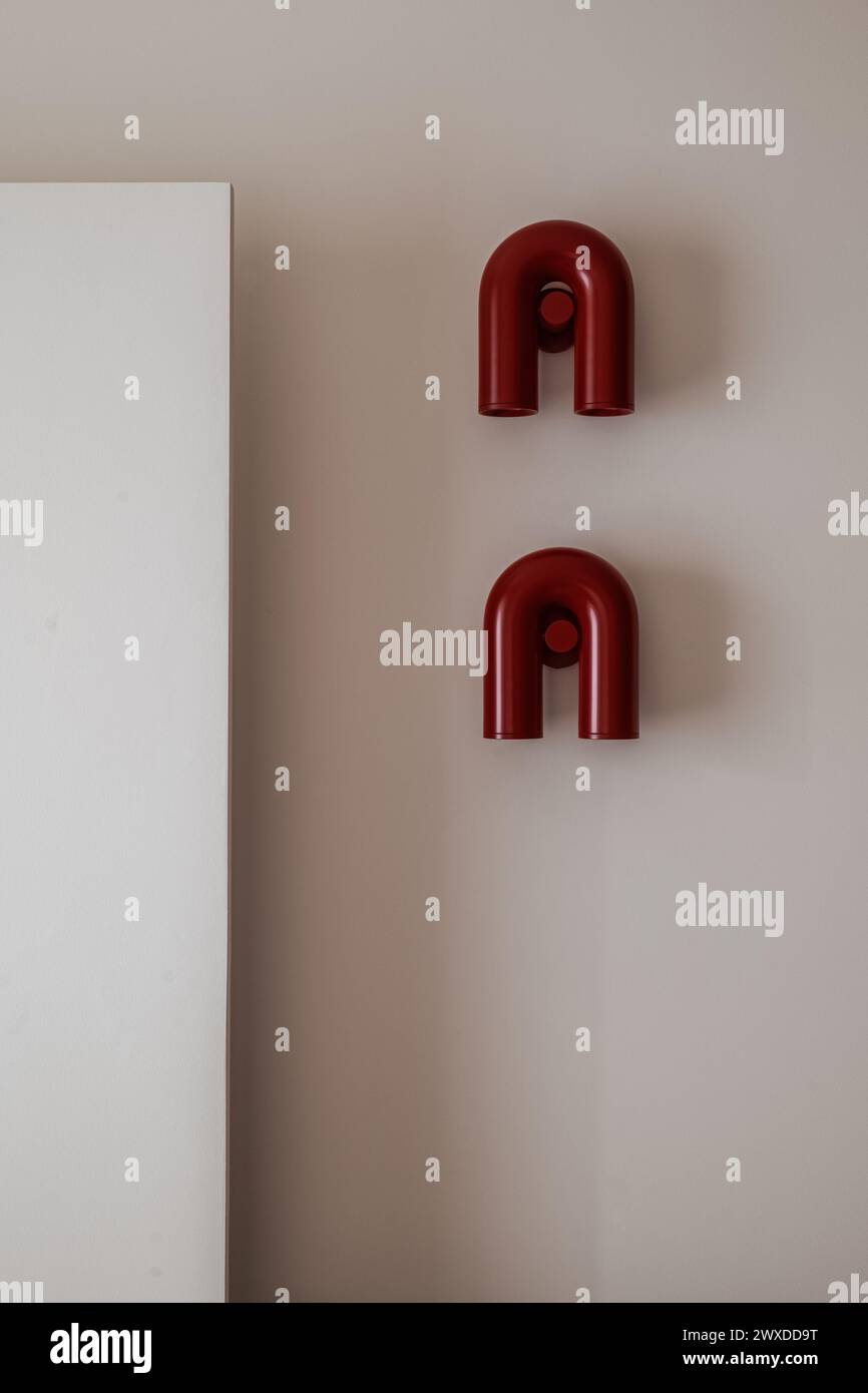 Two magenta candles hang on wood fixture, next to a white wall Stock ...